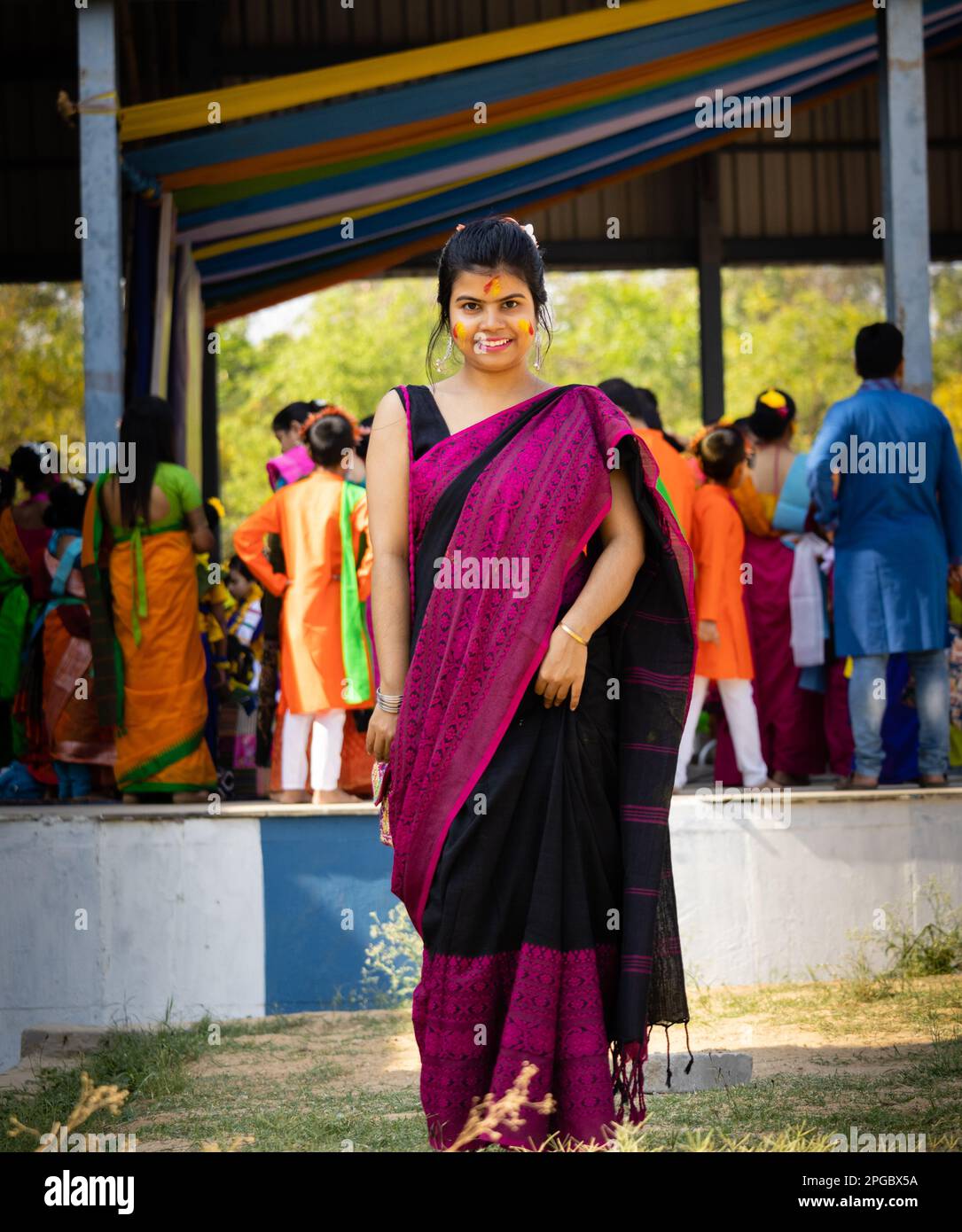 An Indian woman with colorful face looking at camera in holi - the ...
