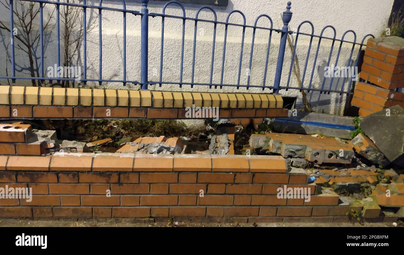 View of a brick wall in a yard that has been partially demolished ...