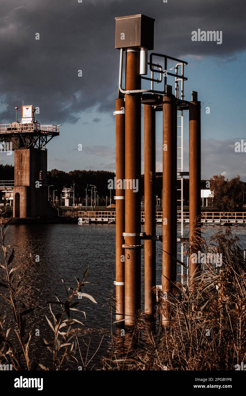 An industrial, galvanized steel pipe juts out of the water, below a ...