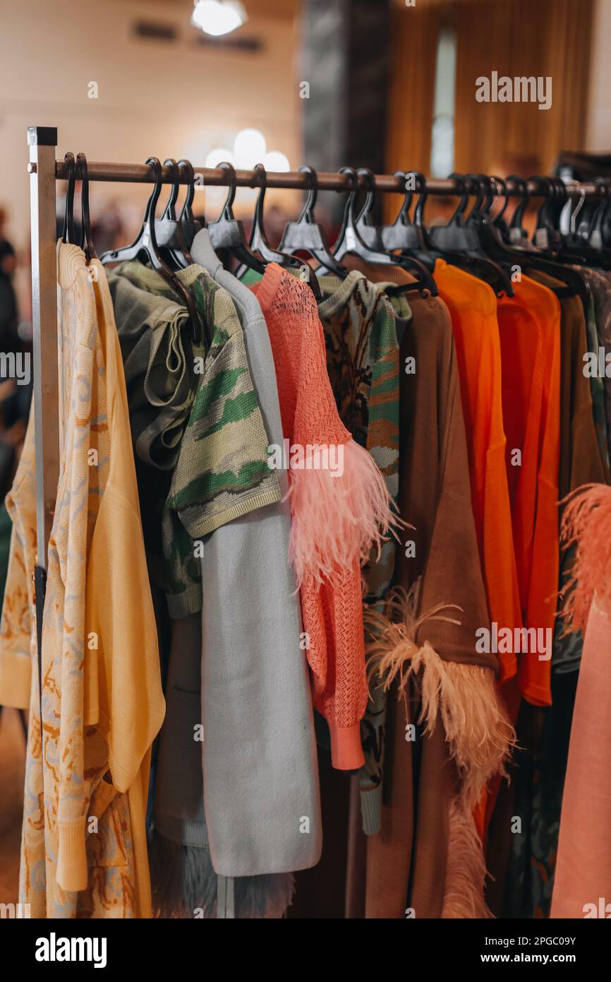 Fashion designer stylish outfits hanging in a row at the backstage ...