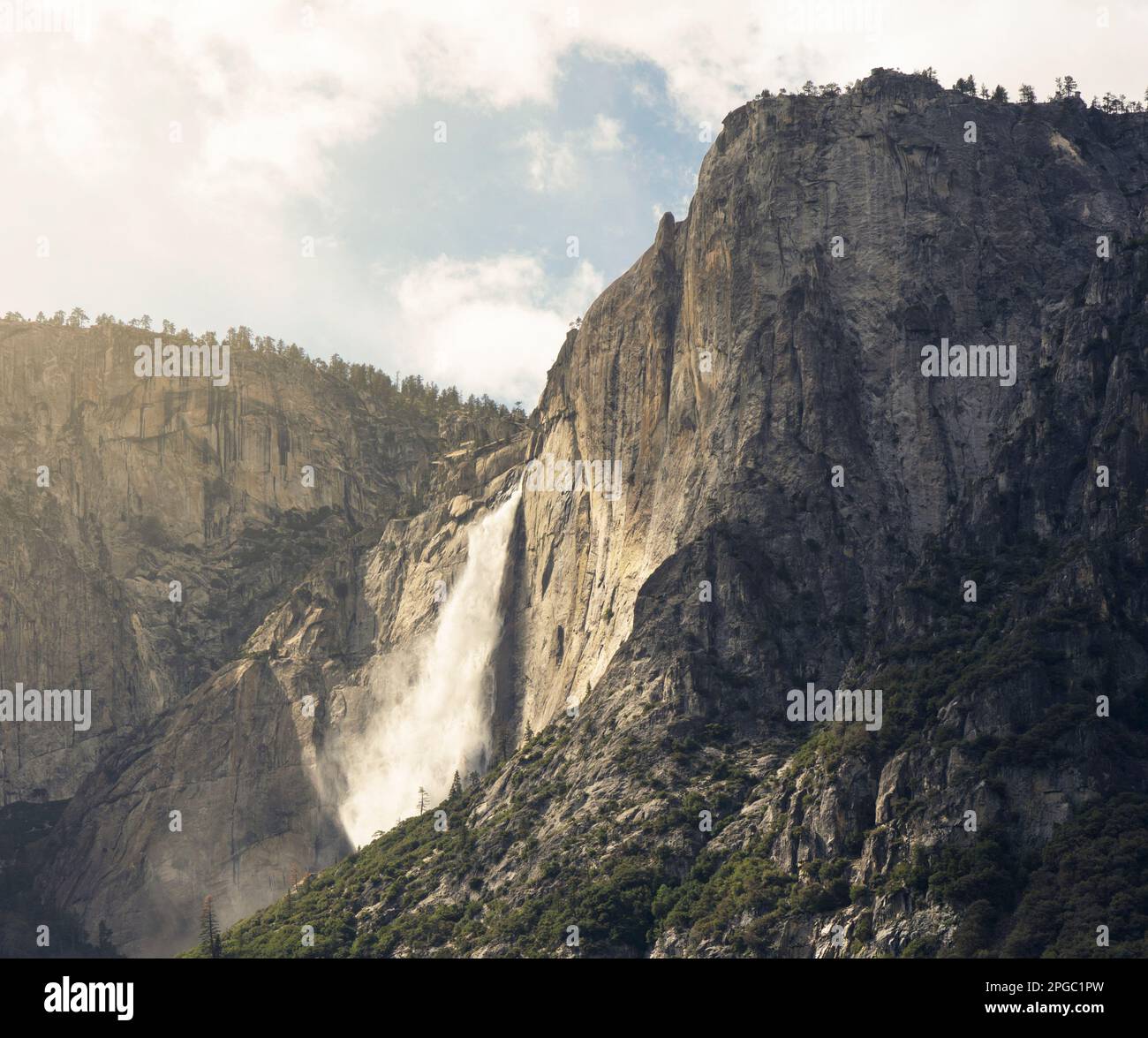 A landscape featuring a dramatic waterfall cascading down its rocky ...