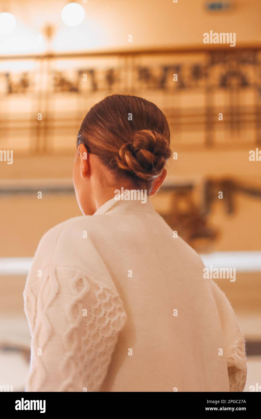 Fashion model in a white autumn cardigan and with an elegant bun ...