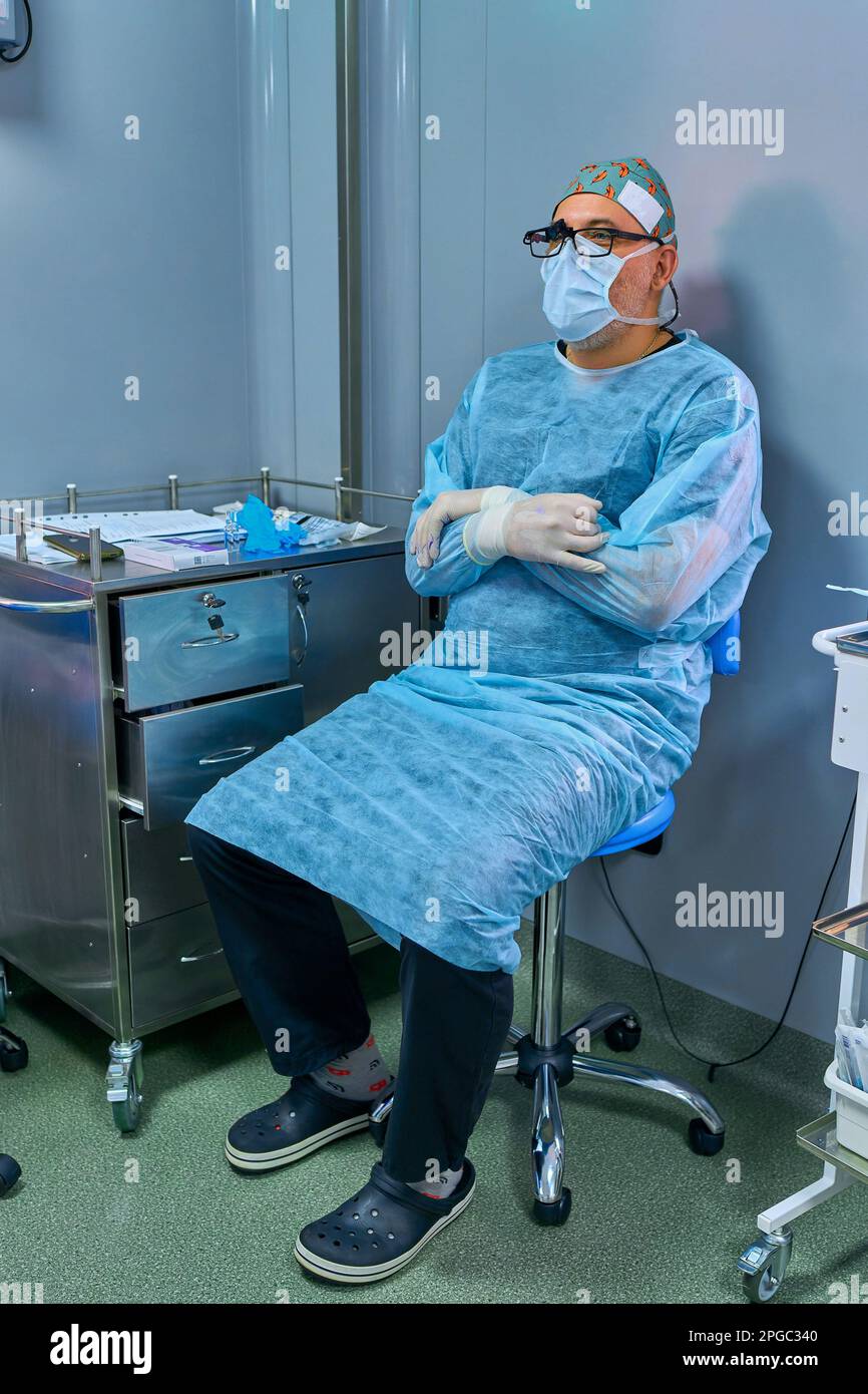 surgeon is sitting on a chair in the operating room Stock Photo - Alamy