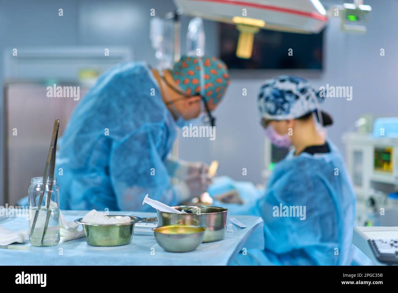 surgeon in the operating room is standing at the table with the patient ...