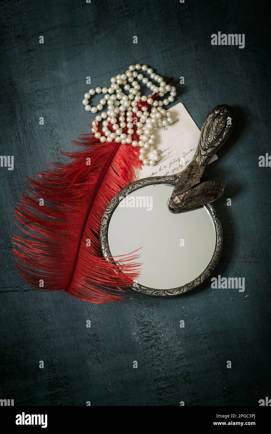 Moth over mirror red feathers and pearl necklace Stock Photo - Alamy