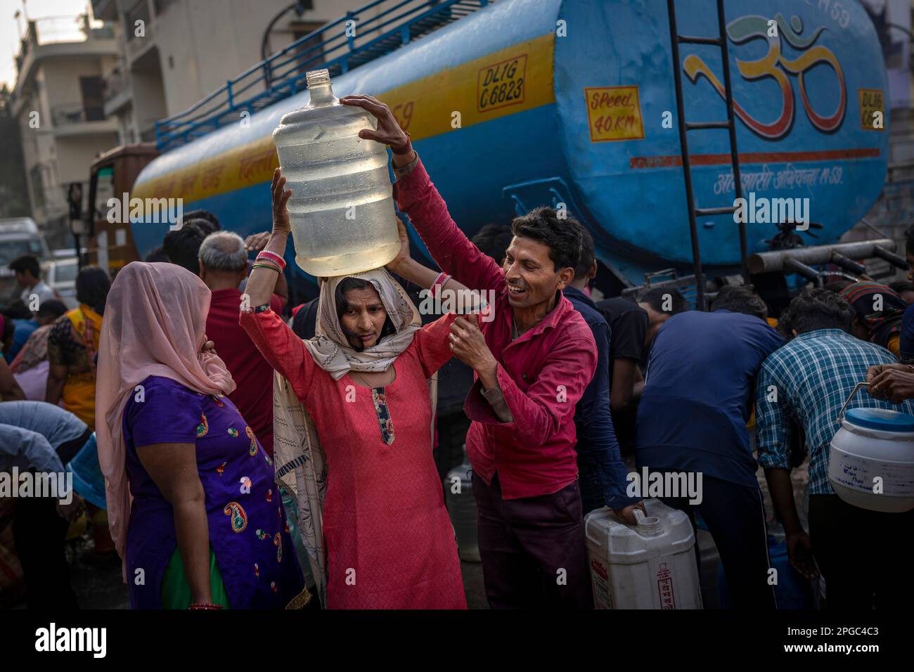 People collect drinking water from a mobile water tanker on World Water ...