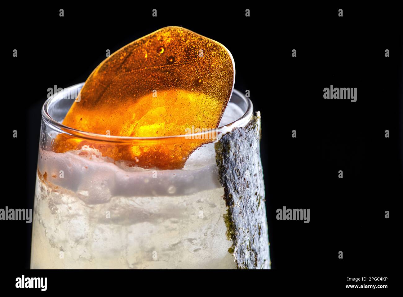 cocktail with vodka in a translucent tall glass filled with ice, dark ...