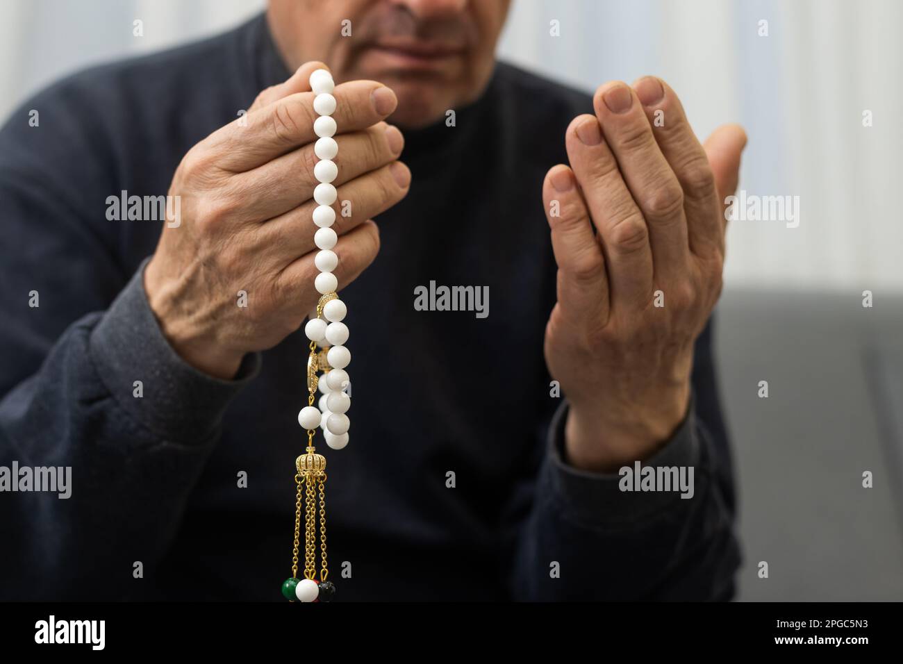 Praying hands of an old man holding rosary beads Stock Photo - Alamy