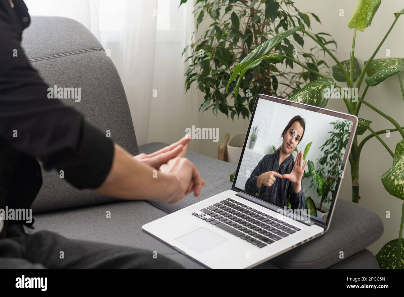 Young man showing gesture in sign language using laptop, make video ...