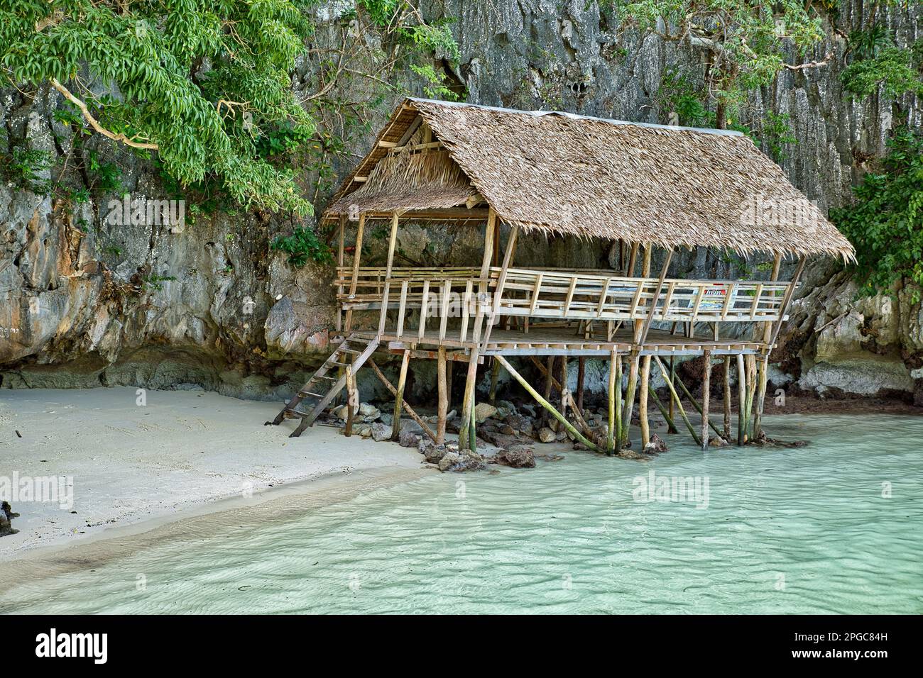 A paradisiacal beach cove in Coron, Palawan in the Philippines with turquoise waters and a hut ...