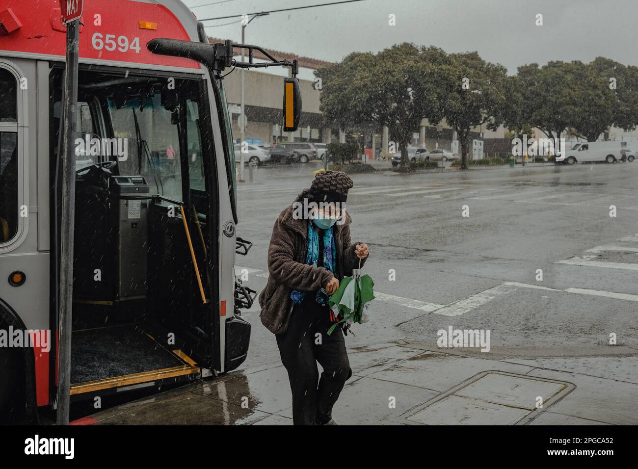 A commuter walking under the rain, braves the weather to get to his ...