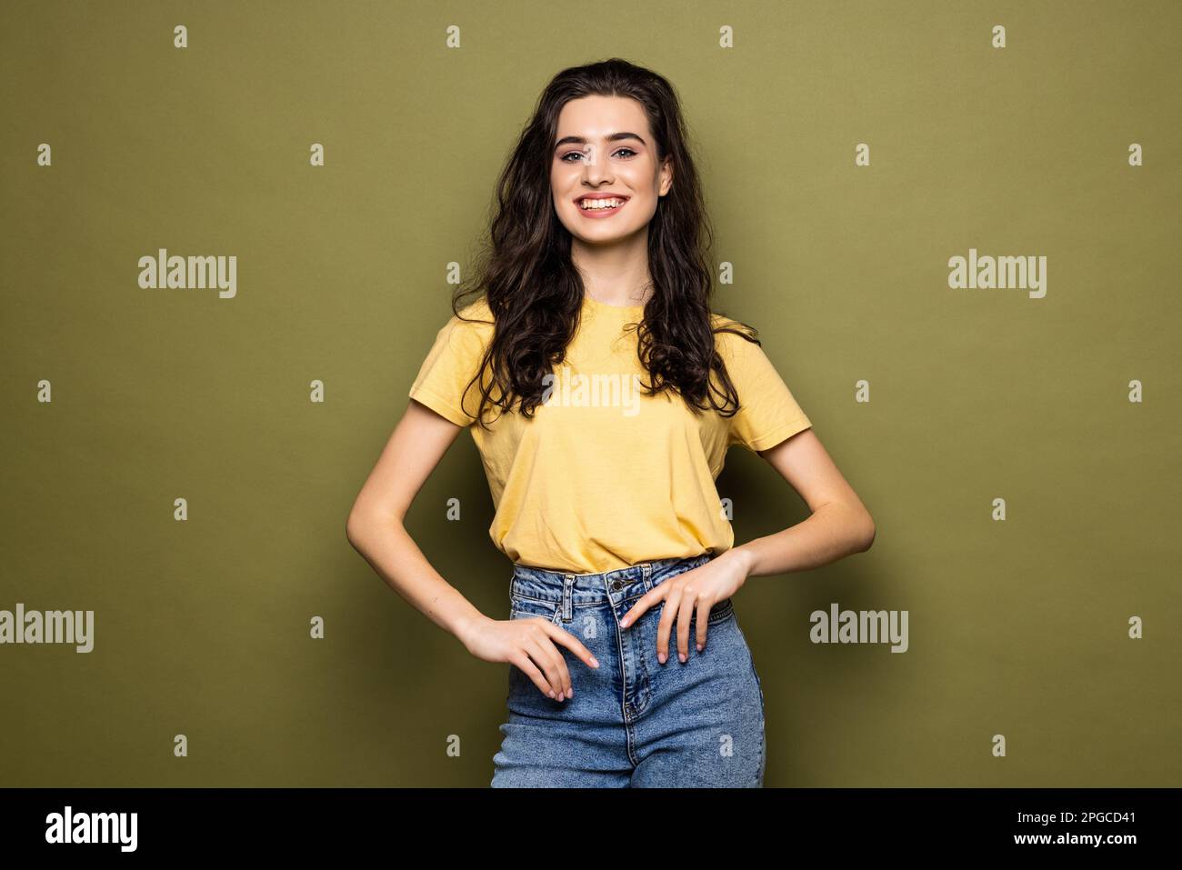 Young smiling attractive girl is posing in close pose with arms ...