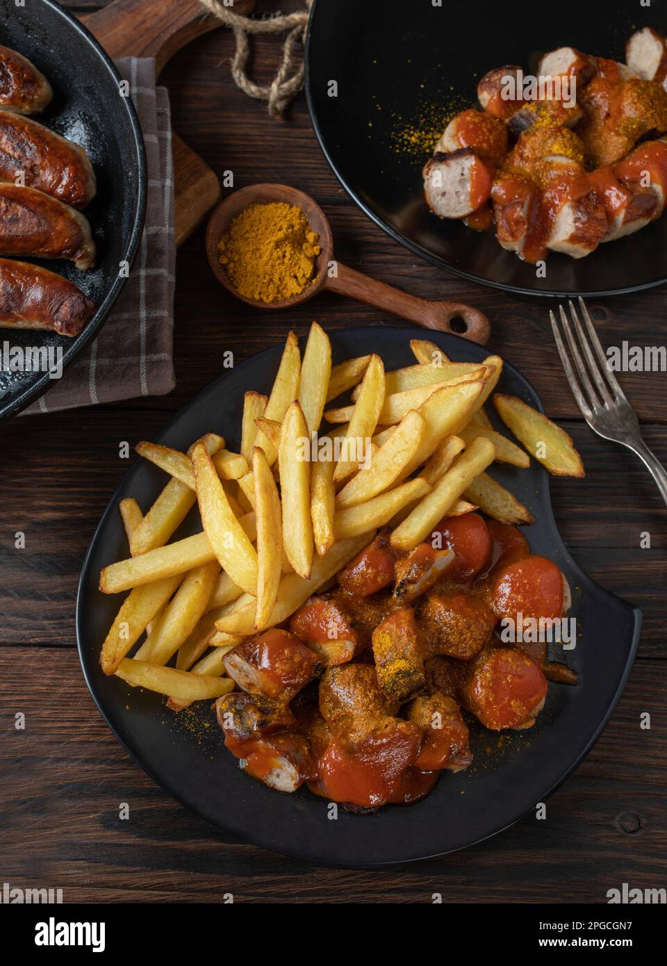 Currywurst or Curry sausage with french fries on rustic and wooden ...