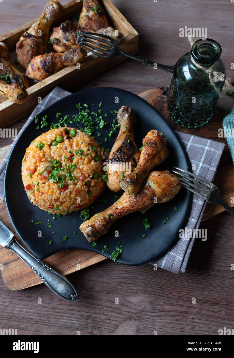 Djuvec rice or serbian rice with baked chicken drumsticks on a plate ...
