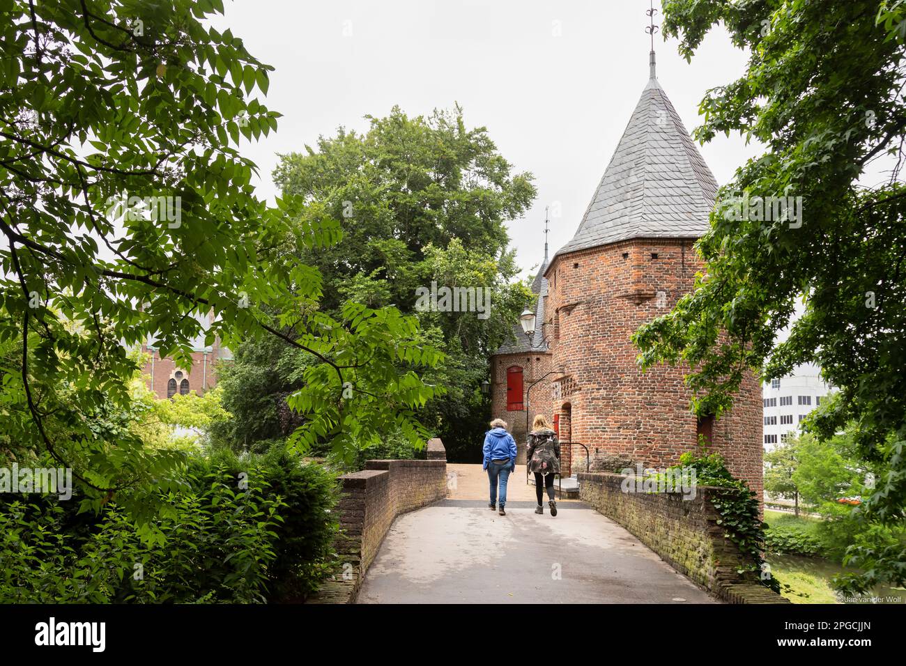 People walk on the footpath over the medieval water gate de Monnikendam ...