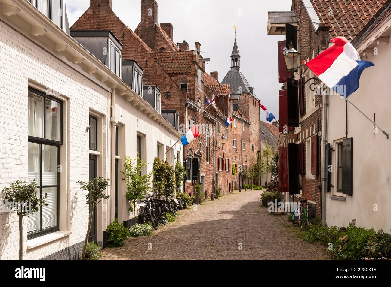 Narrow street with Dutch flags in the old medieval center of the Dutch ...