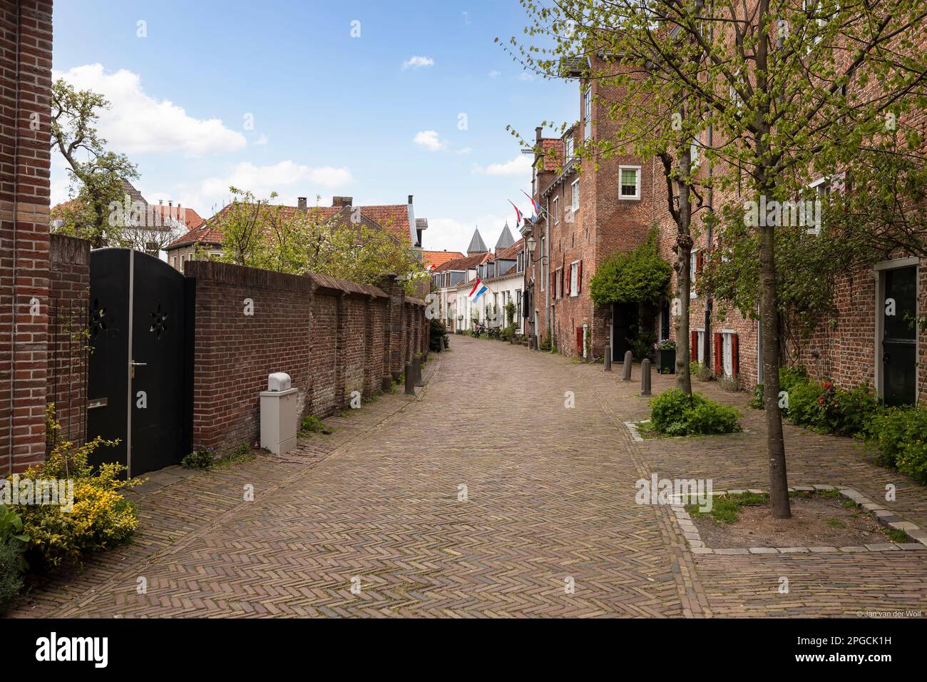 Narrow street with Dutch flags in the old medieval center of the Dutch ...