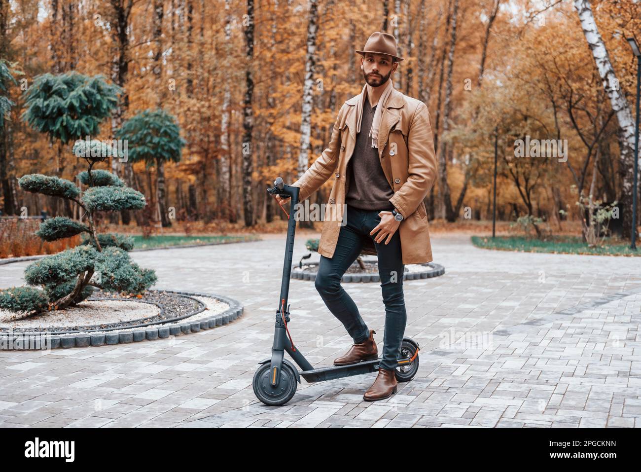 In the park on electric scooter. Young male model in fashionable ...