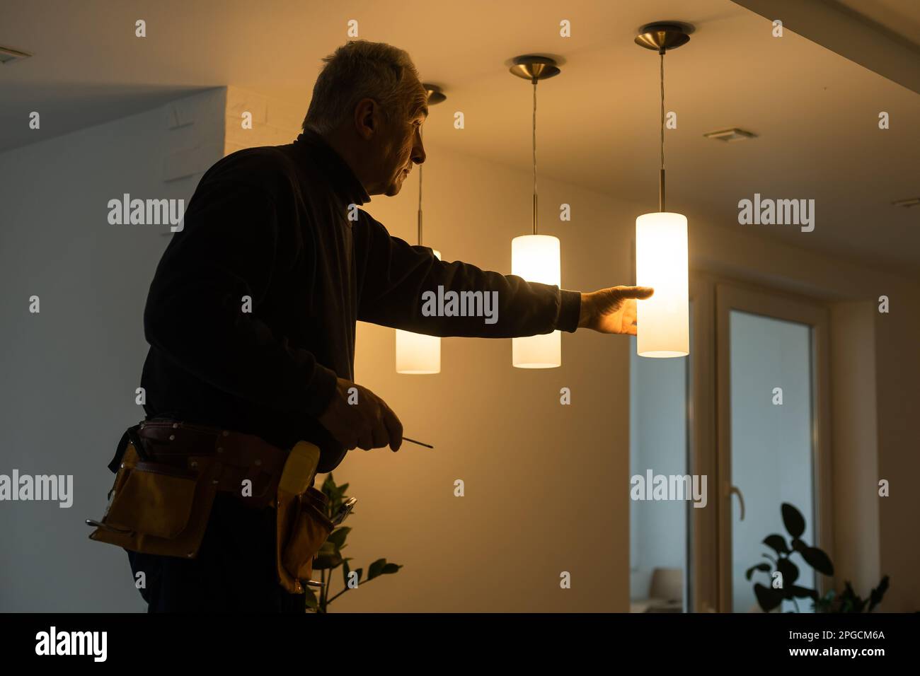 Elderly man changing light bulbs : Retired man doing household chores ...