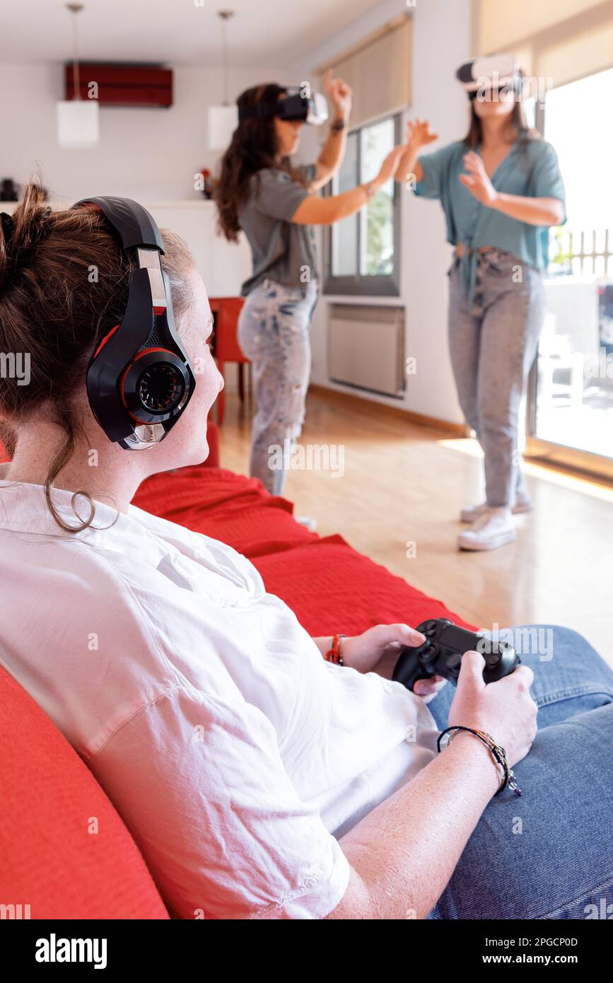 Side view of young females in VR goggles dancing on floor with ...