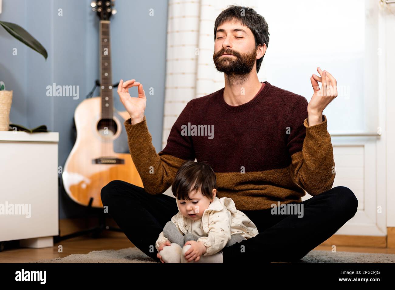 Full body of relaxed bearded father in casual clothes sitting in lotus ...