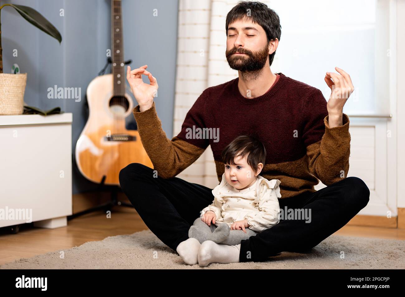 Full body of relaxed bearded father in casual clothes sitting in lotus ...