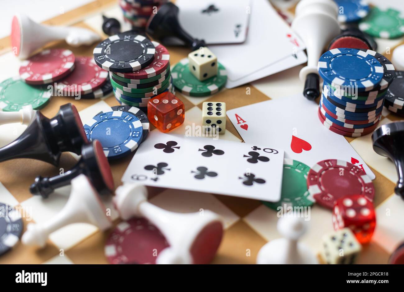 Wooden checkers, chess pieces, playing cards, board games on a light ...