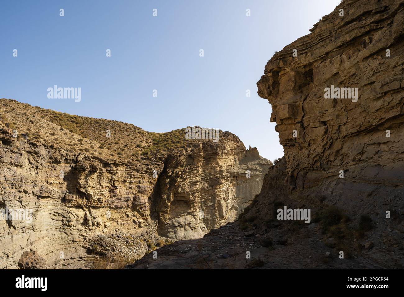 Rough rocky cliffs covered against cloudless blue sky located in ...
