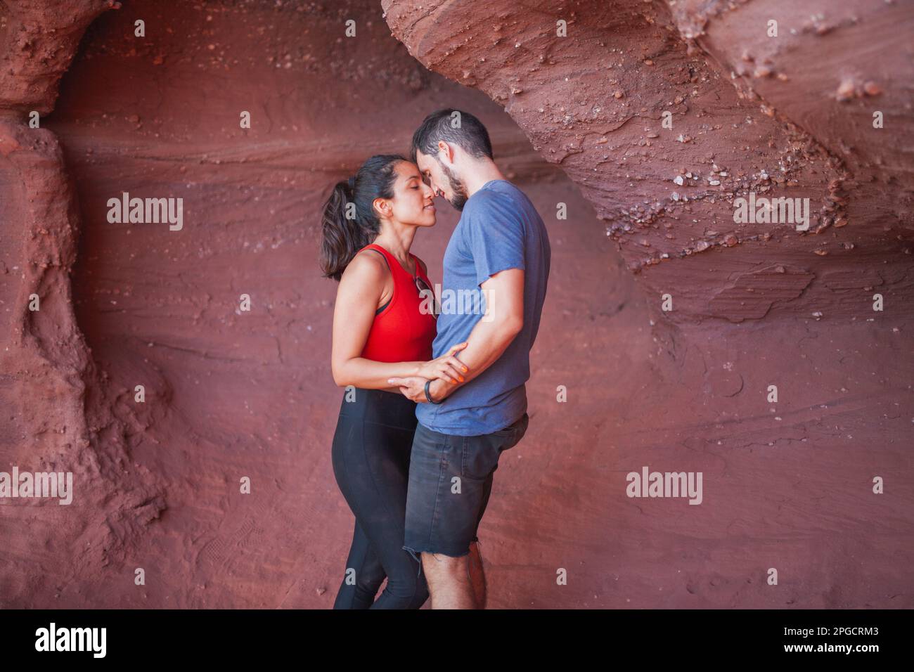 Side view of young man and woman wearing casual clothes hugging and ...