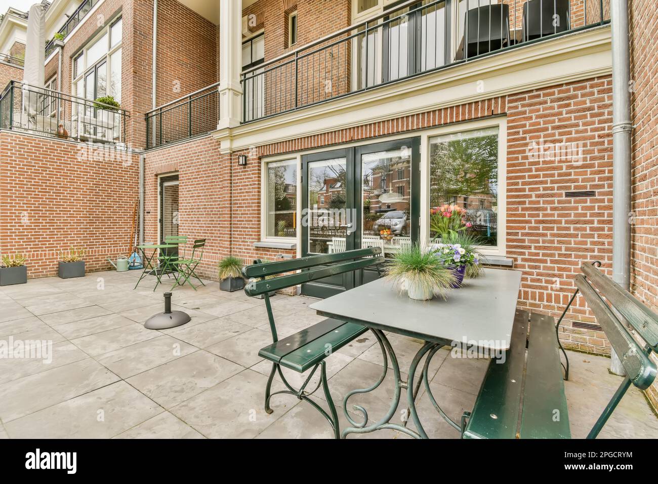 Exterior of modern brick building with cafe on first floor and table ...