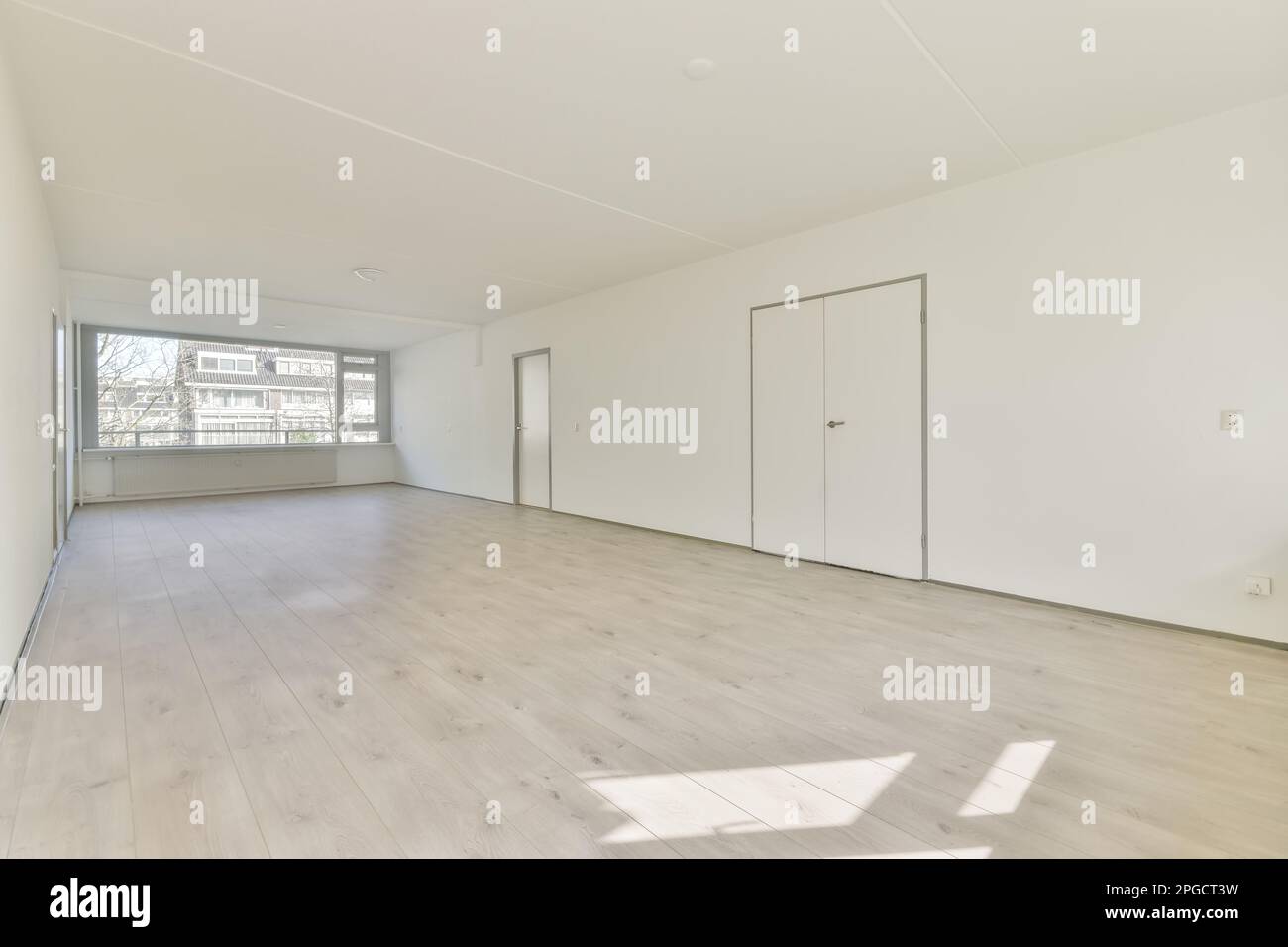 Interior of light empty room with laminate floor and window in ...
