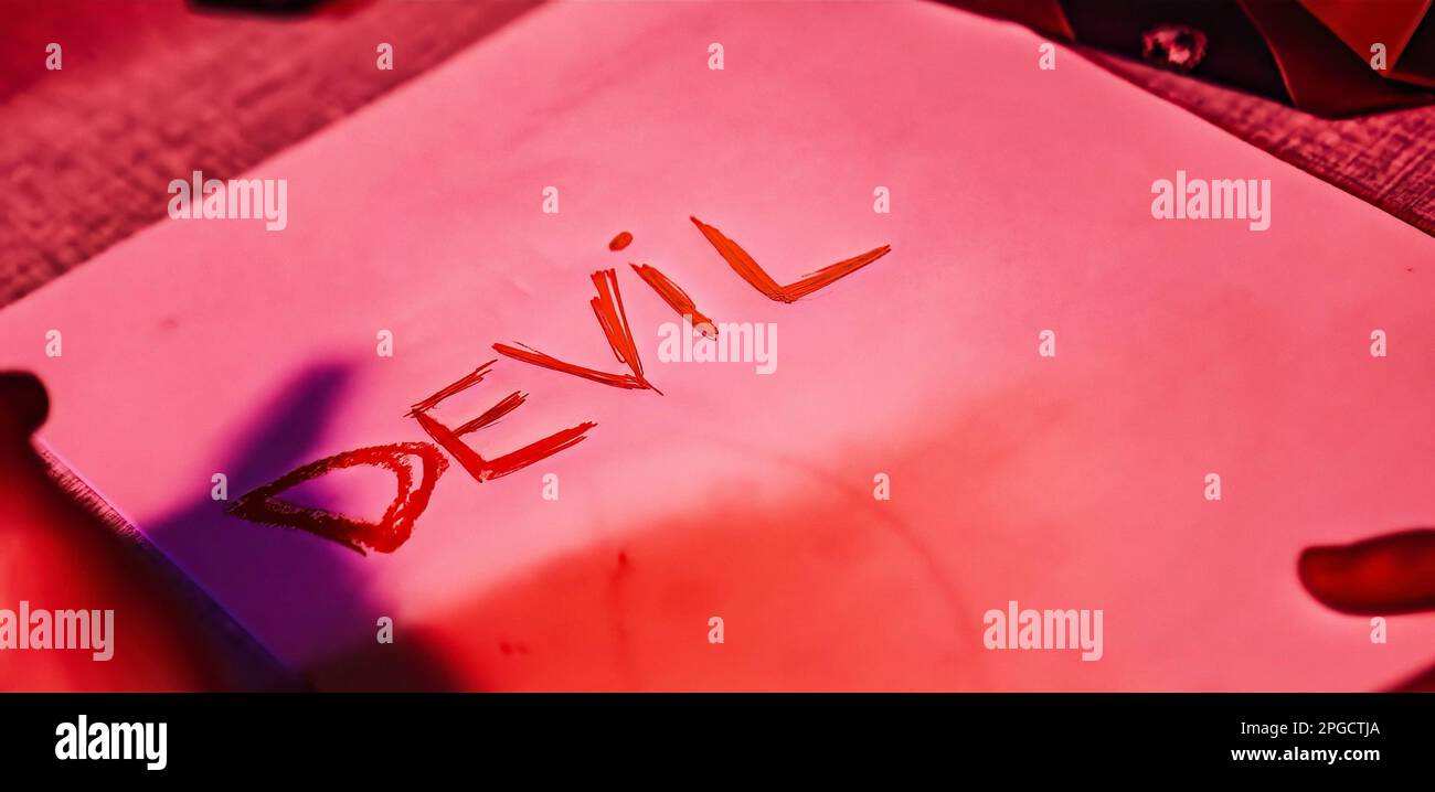 A close-up shot of a paper with the word 'Devil' written in cursive ...