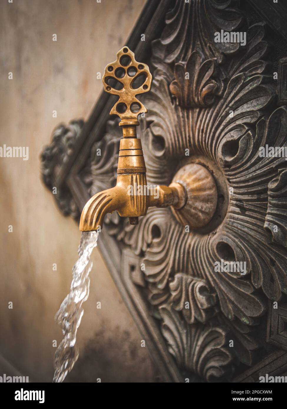 A tap is releasing a stream of crystal clear water which flowing over ...