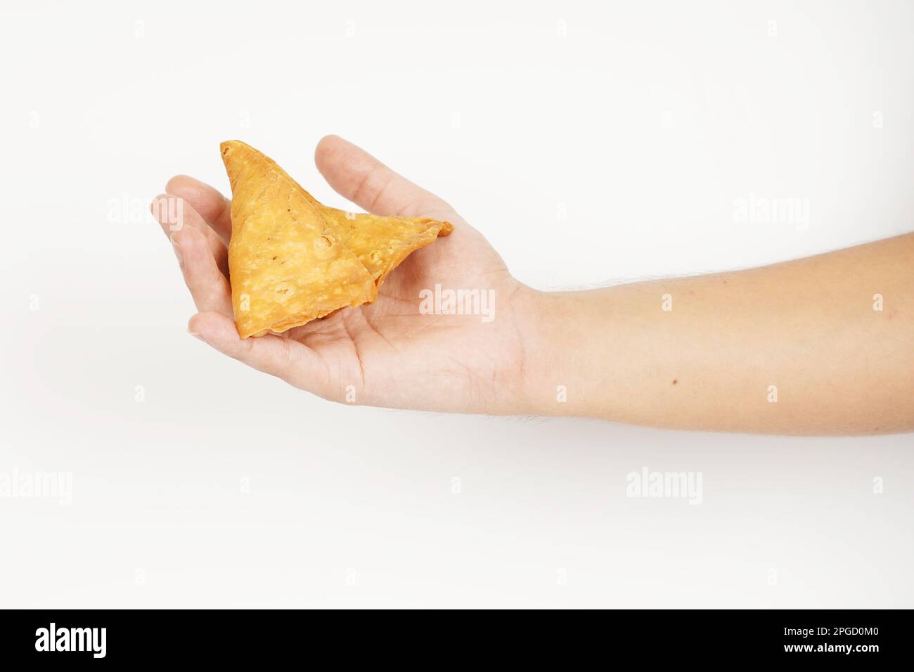 Samosa in hand isolated on white background Stock Photo - Alamy
