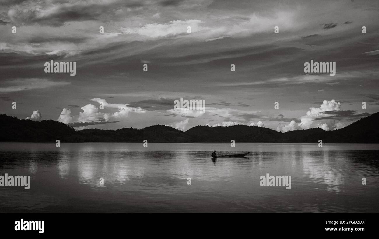 A lone Mnong ethnic minority man on his wooden canoe heads out to fish ...