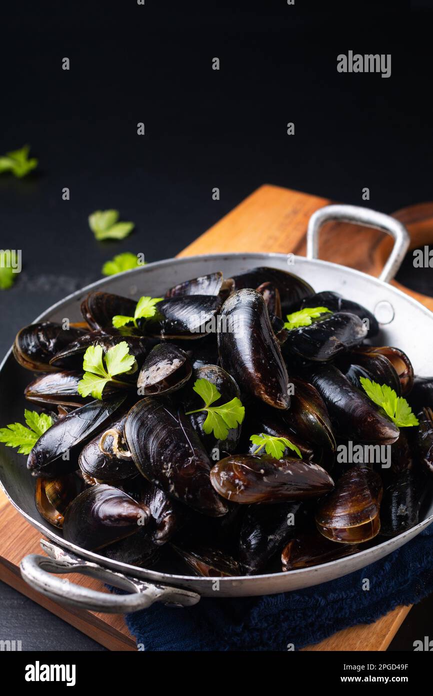 Food concept Fresh Mussels in the pan on black background with copy ...