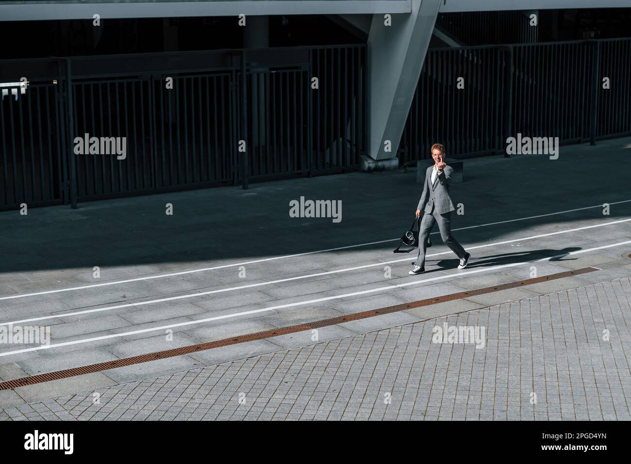 Shows middle finger. Young successful businessman in grey formal wear ...