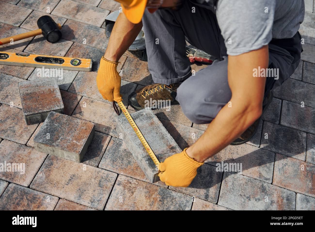 Measuring process. Male worker in yellow colored uniform have job with ...