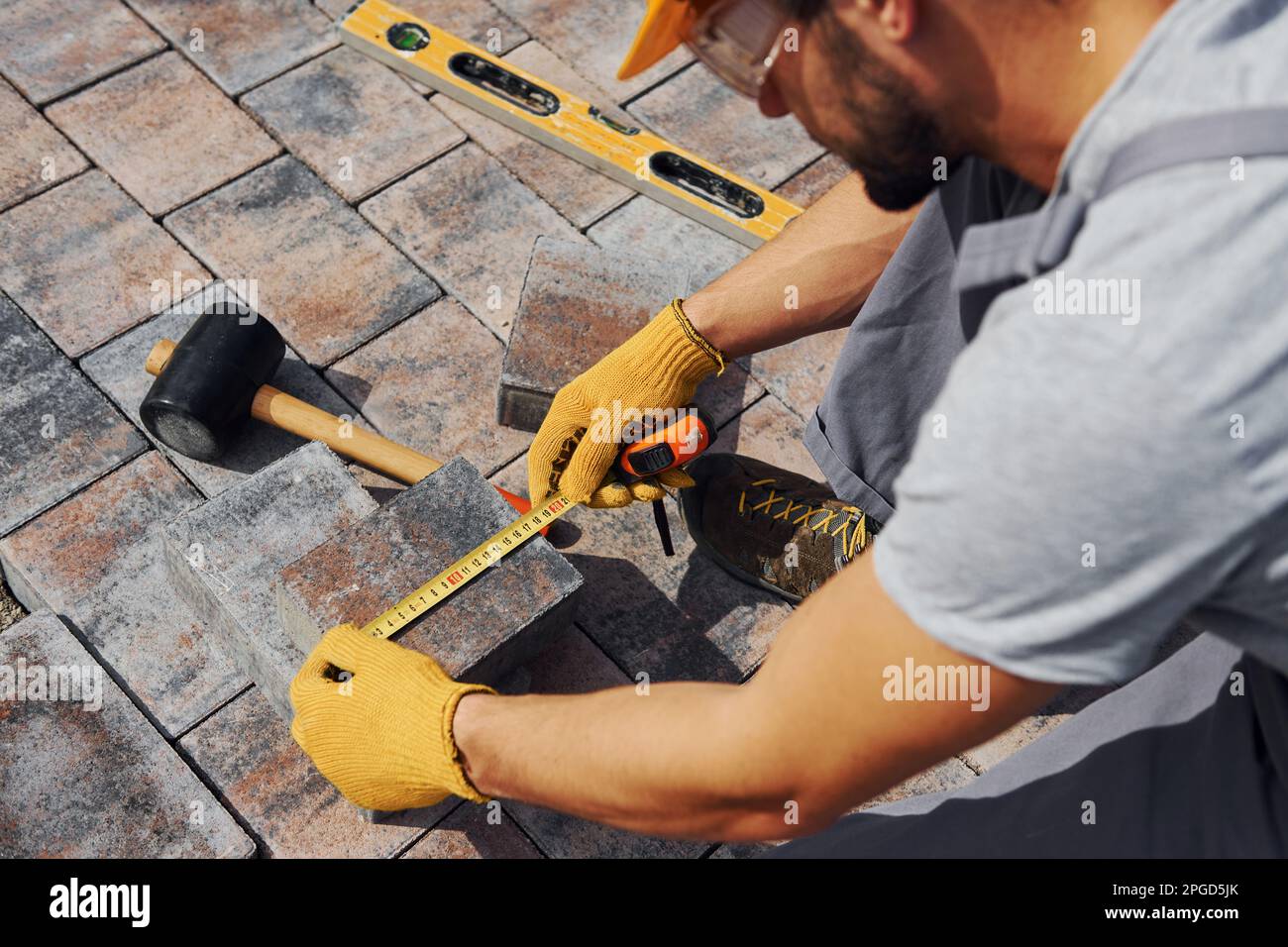 Measuring process. Male worker in yellow colored uniform have job with ...