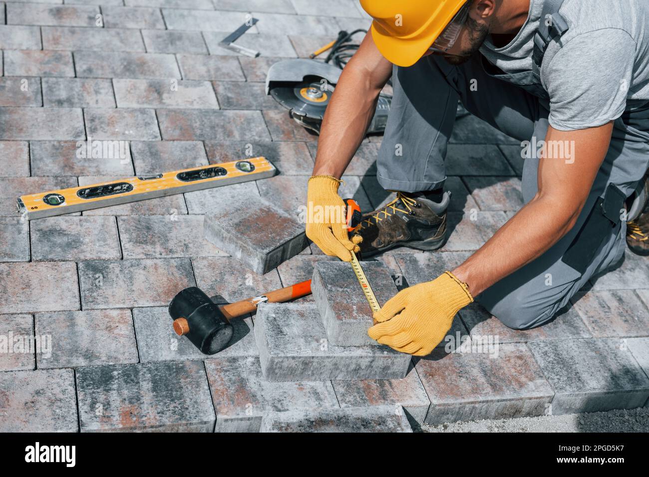Measuring process. Male worker in yellow colored uniform have job with ...