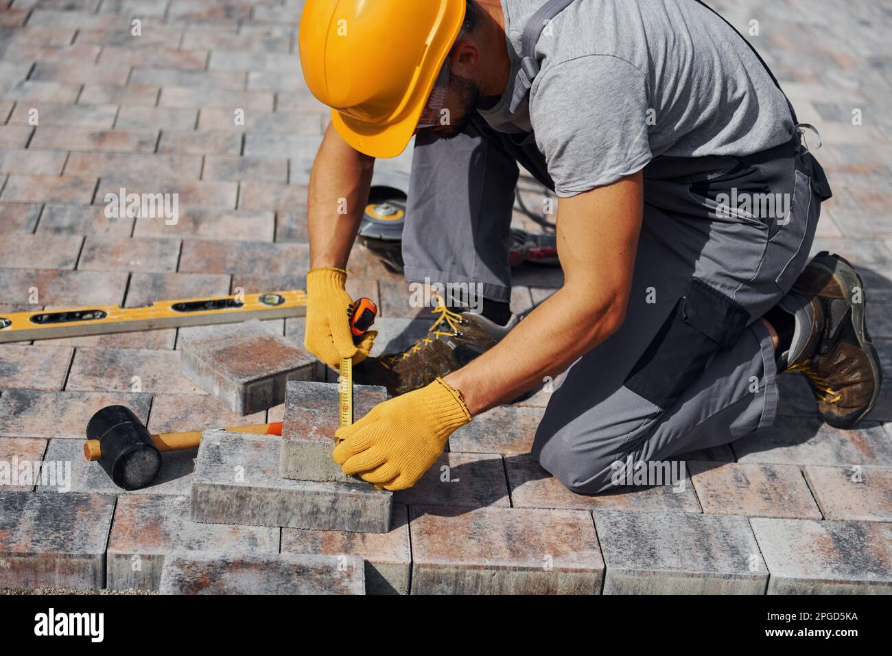 Measuring process. Male worker in yellow colored uniform have job with ...