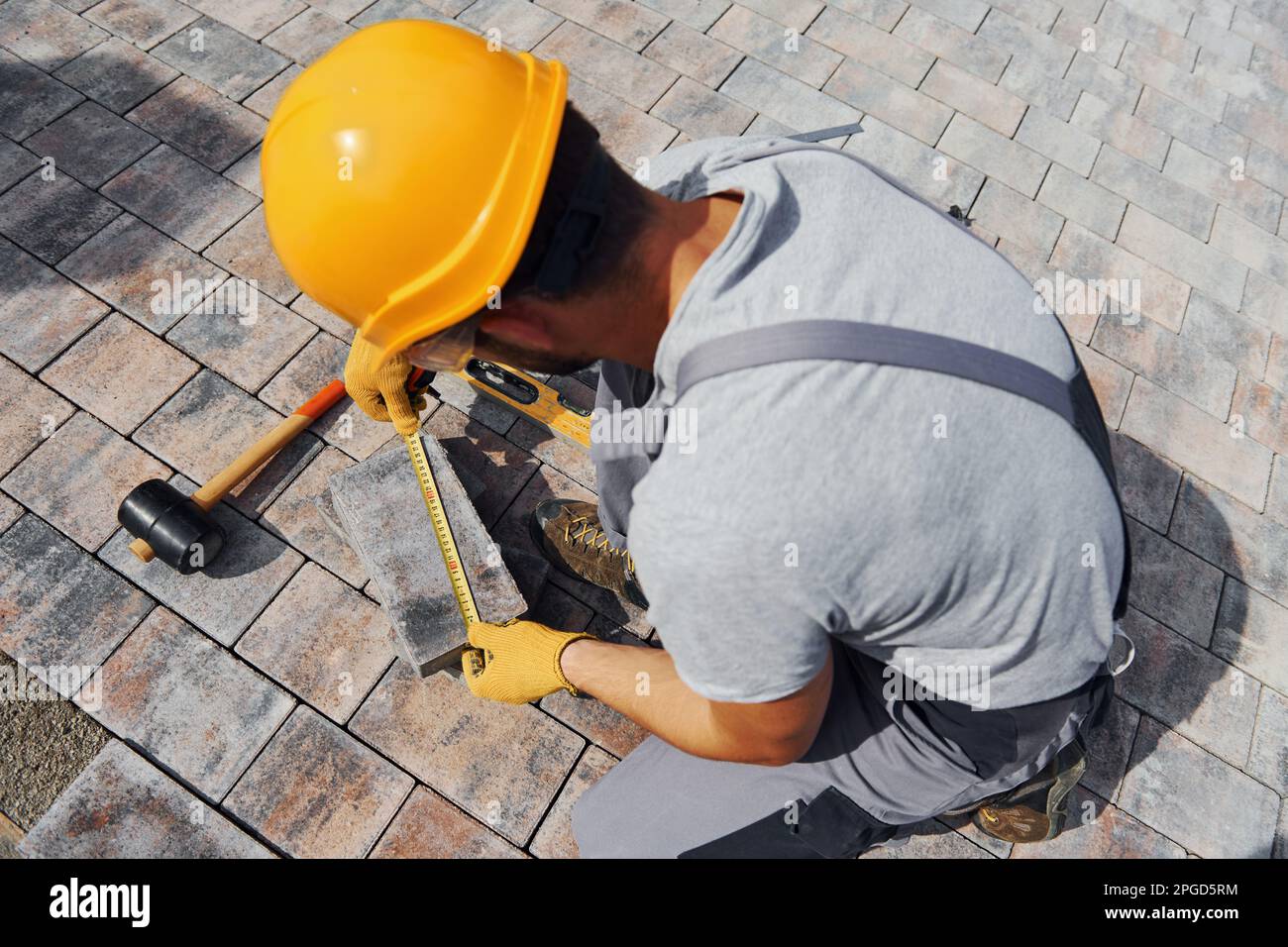 Measuring process. Male worker in yellow colored uniform have job with ...