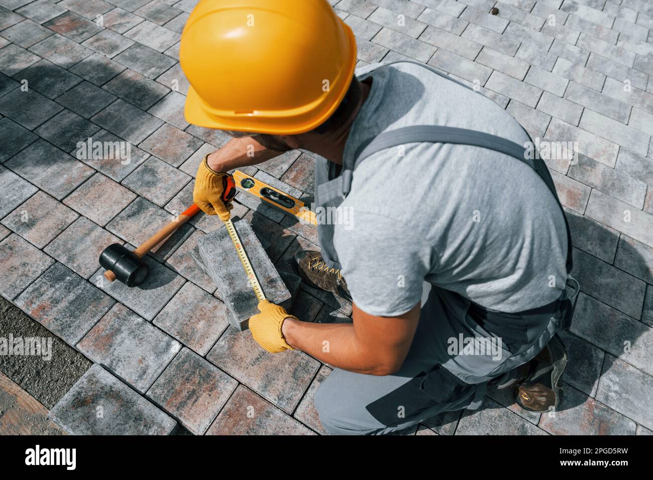 Measuring process. Male worker in yellow colored uniform have job with ...