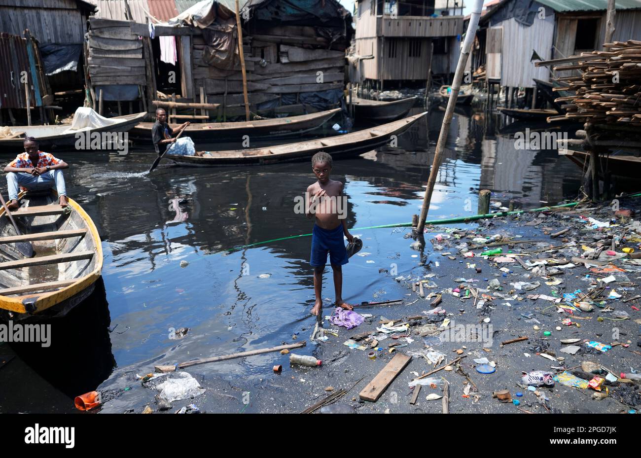 A child stands in filthy water surrounded by garbage in Nigeria's ...