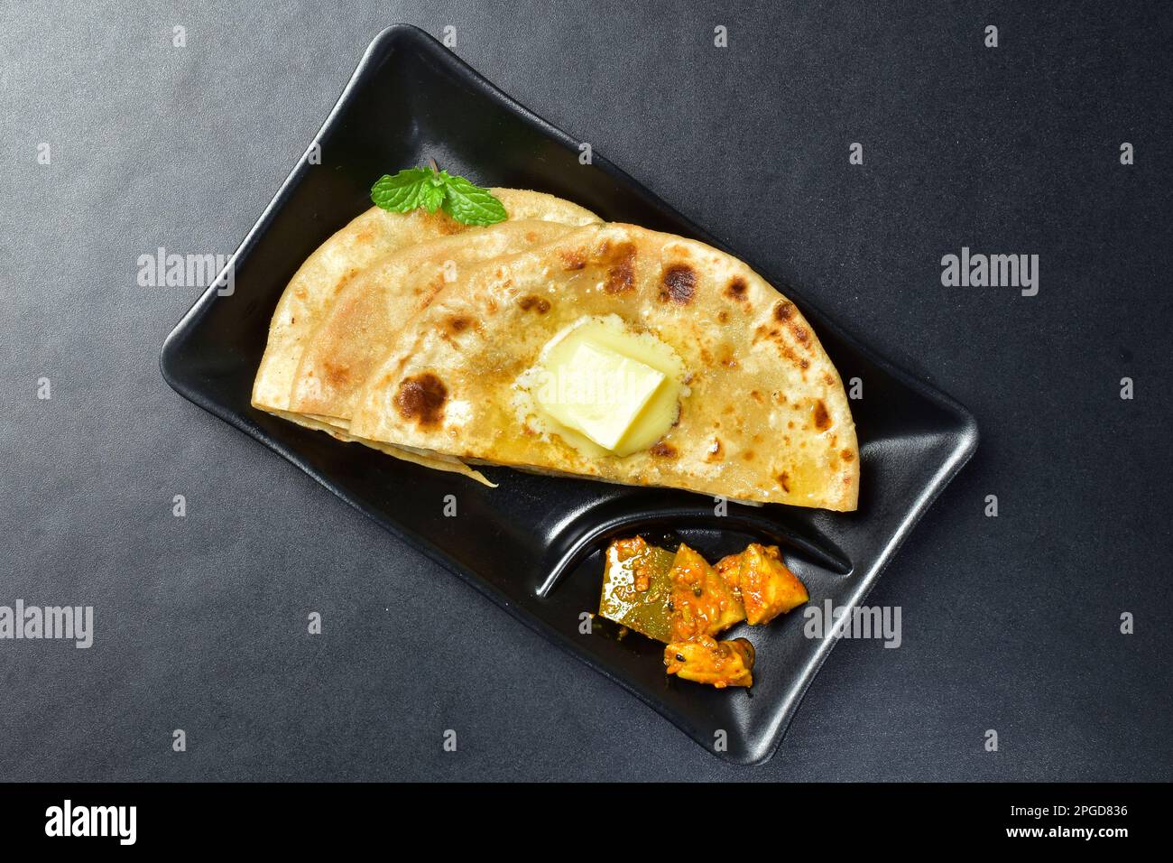 Top view of butter aloo paratha with aam ka aachar in plate, healthy ...