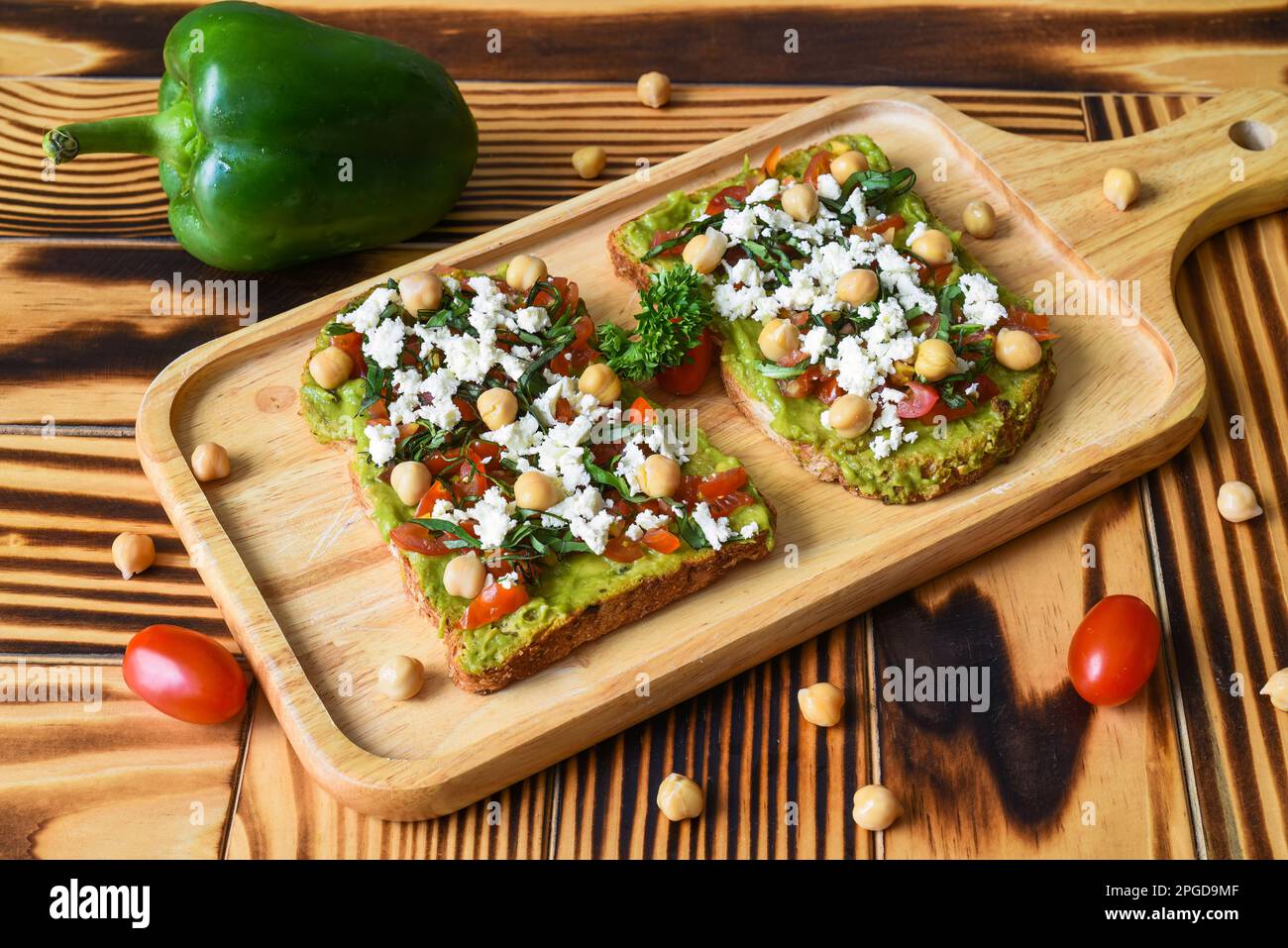 Vegetarian classic avocado toast with tomato tofu cheese on wooden ...