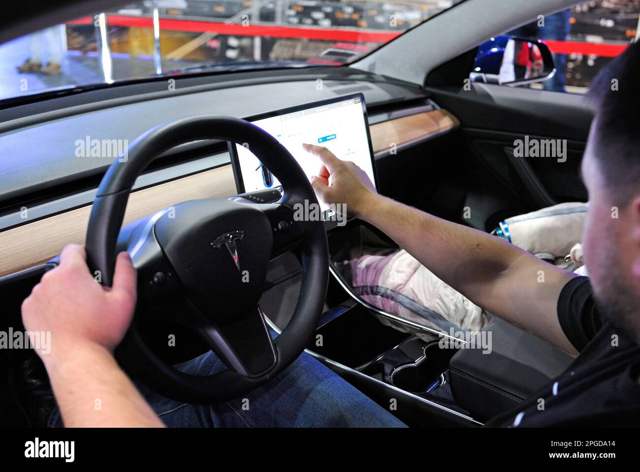 Male driver manipulating a touch screen monitor in cabin of a new ...