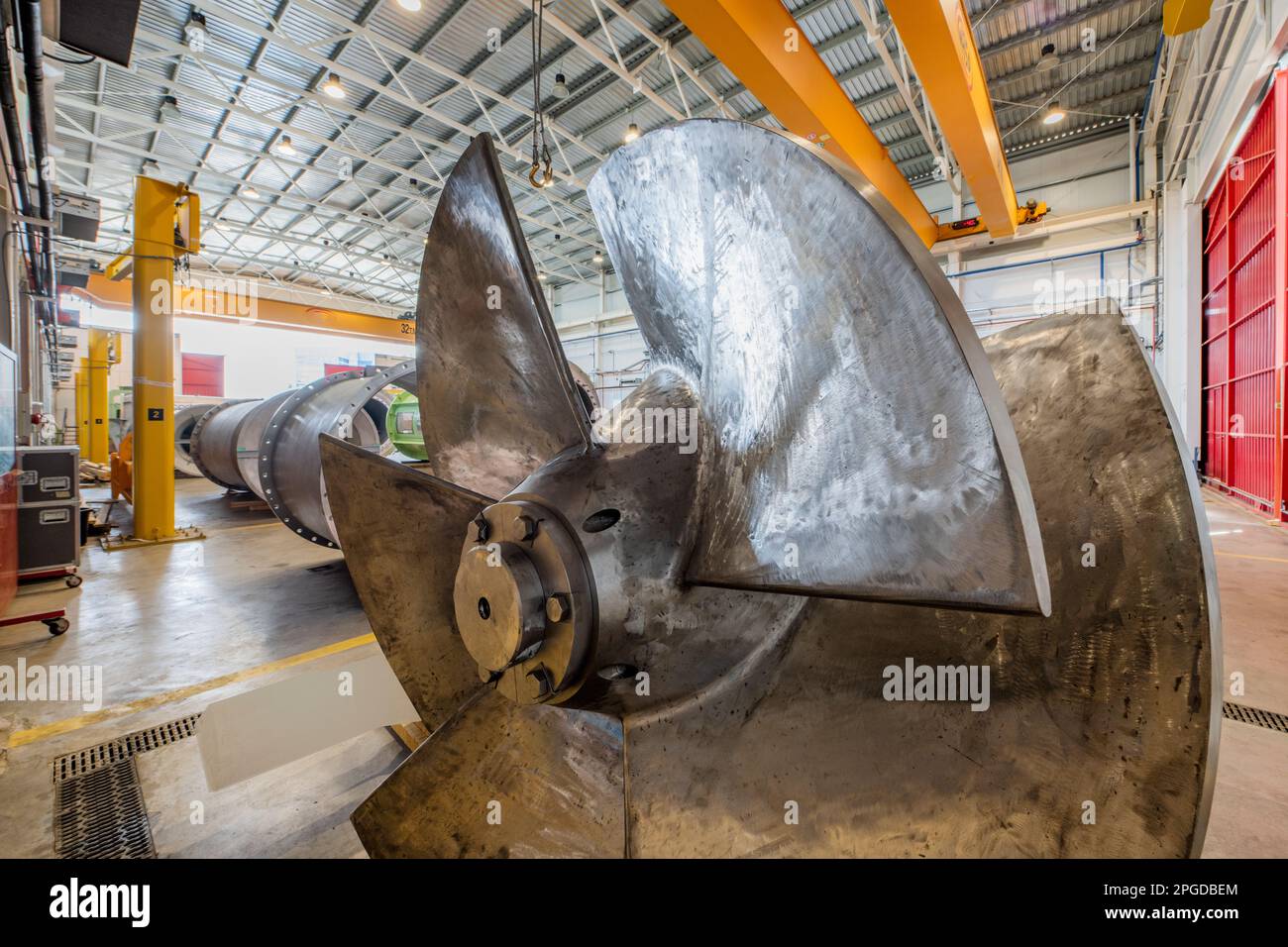 A large metal oil rig propeller in an industrial warehouse along with ...