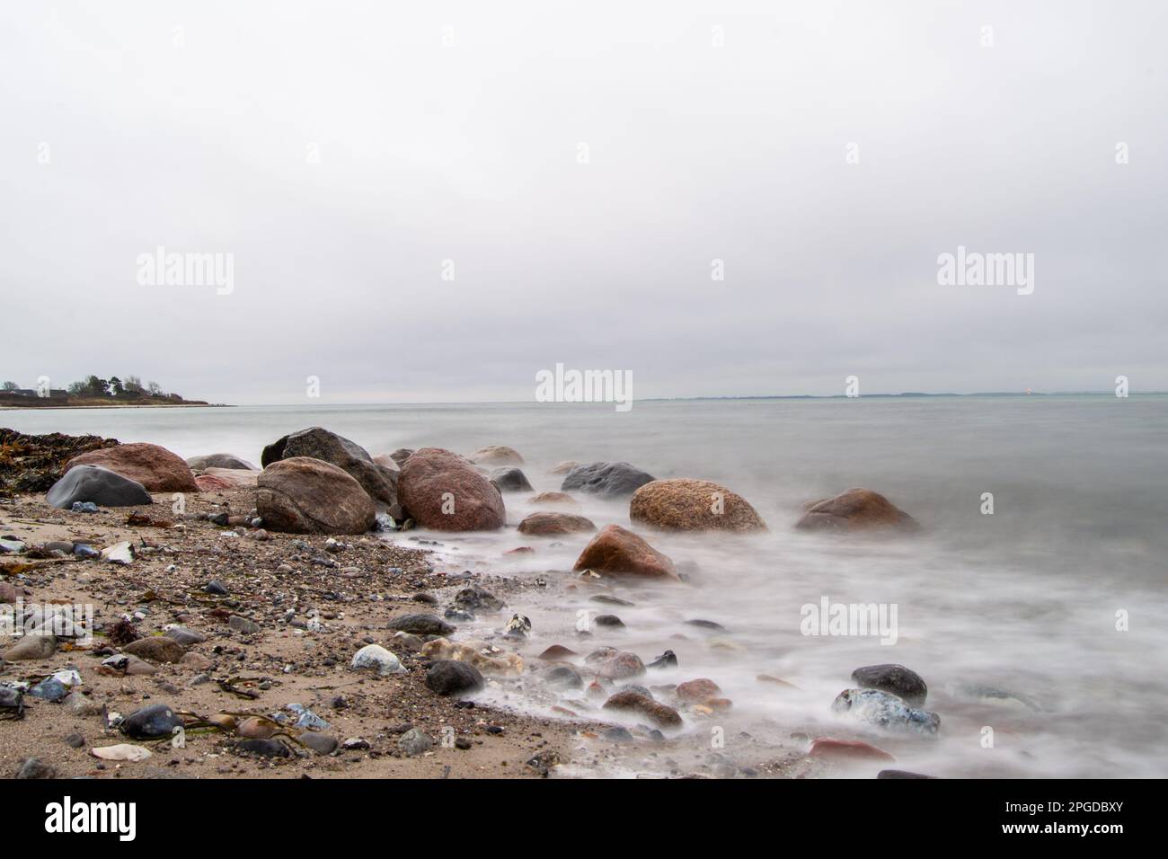 A tranquil beach landscape featuring a shoreline of gently rolling ...