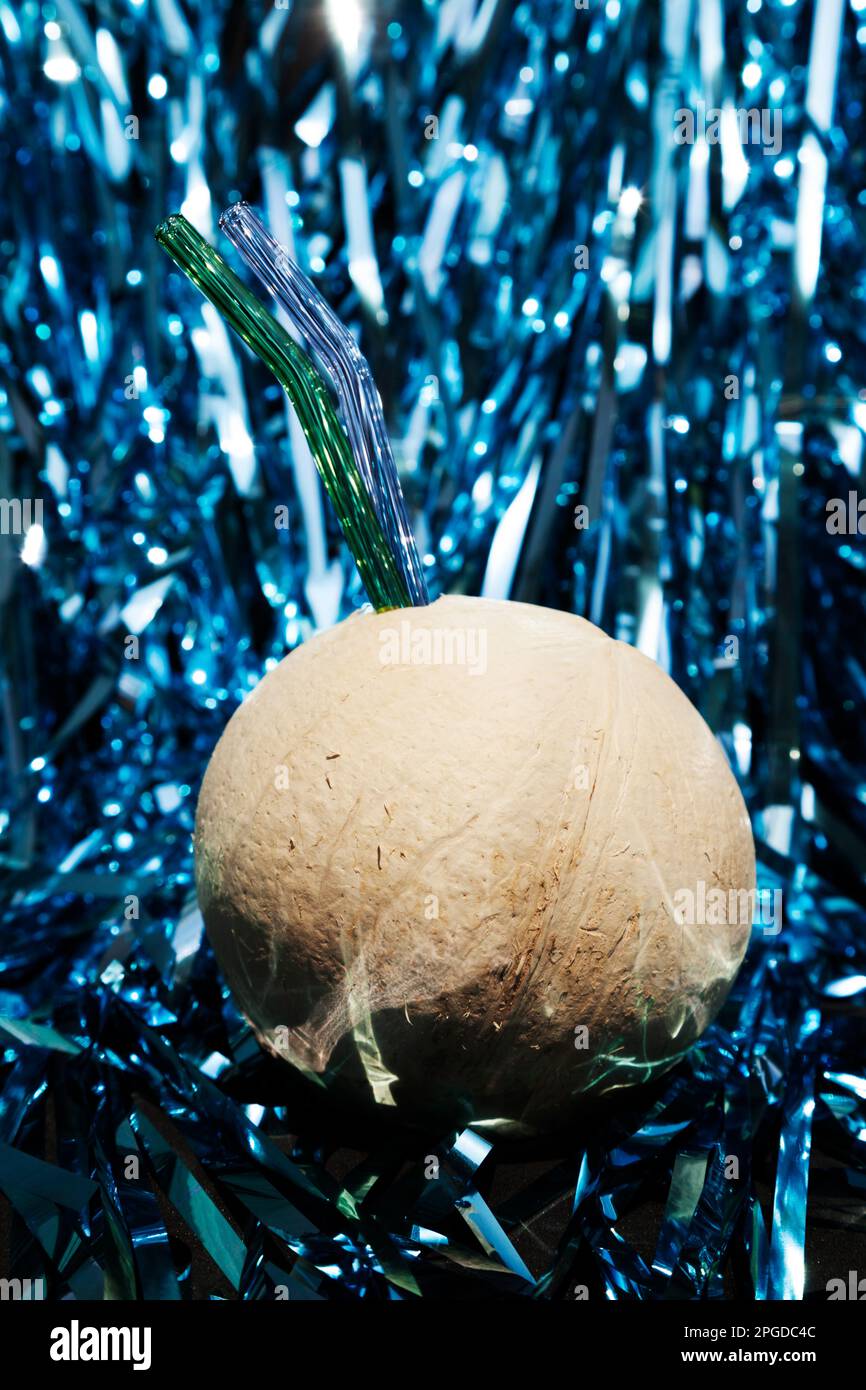 Coconut water drink with 2 glass straws at a party. Fresh coconut juice ...